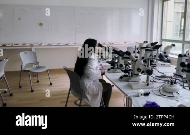Female research scientist looking at samples under microscope. 4K ...