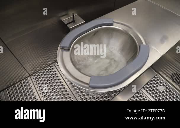 Sanitary metal urinal, toilet bowl in public bathroom with hygienic ...