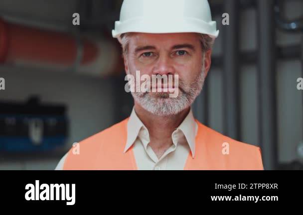 Portrait of handsome mature male engineer posing on background of metal ...