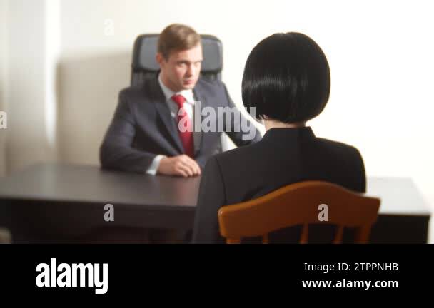 a man in a suit asks questions to a brunette woman in an interview. 4k ...