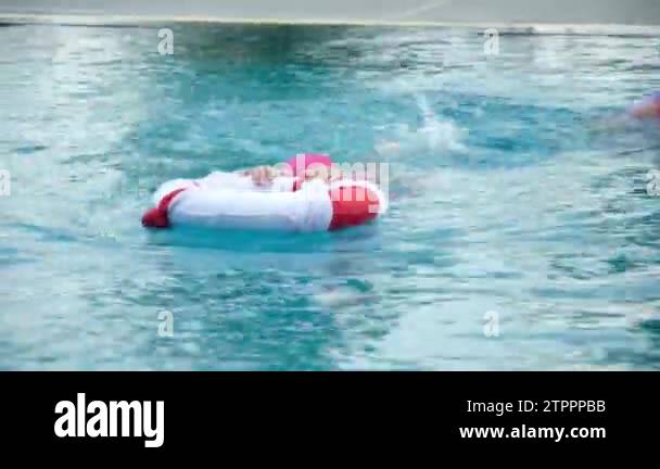 Little girl plays in the outdoor swimming pool of tropical resort ...