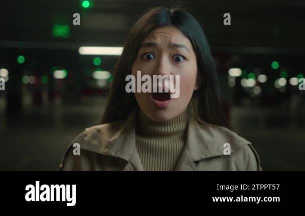 Close up shocked confused frightened Asian chinese korean woman girl at night underground ...