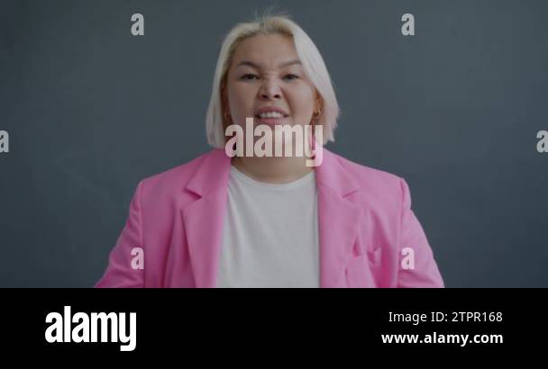 Slow motion portrait of happy Asian woman raising arms and screaming ...
