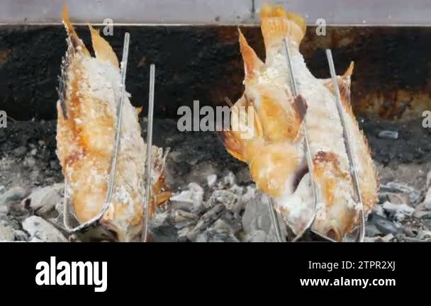National Thai dish, fried fish on spit in salt and with greens. Exotic ...
