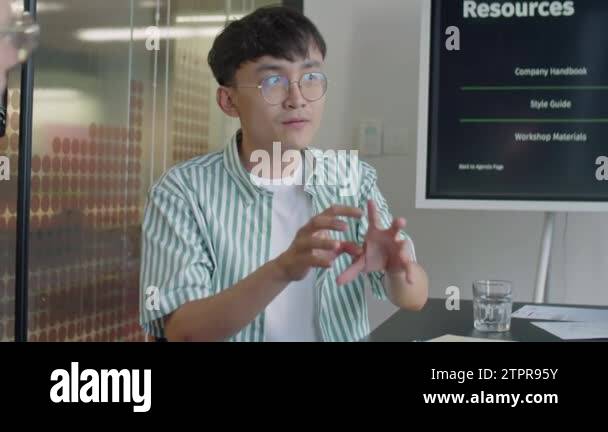 Over the shoulder shot of Asian gen Z man explaining business ideas to ...