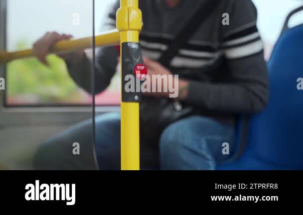 Close up shot man stands up to push red stop button on handrail in ...