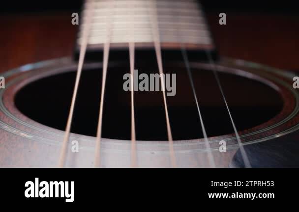 Acoustic guitar strings vibrating. Playing on classic music instrument ...