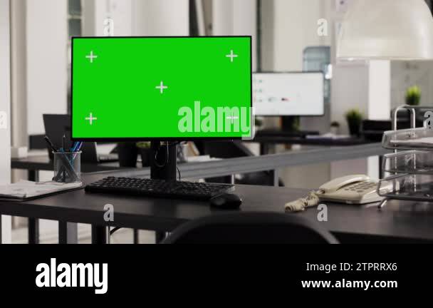 Empty desk with computer shows greenscreen on monitor, running blank ...