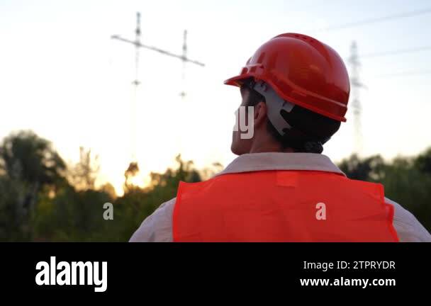 Electrical engineer working outdoors while looking at the high voltage ...