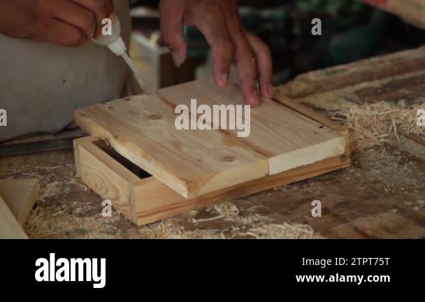 Close up of a carpenter working in a simple wood workshop. The workshop ...