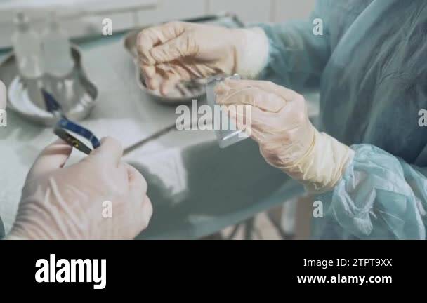 Surgical table with sterile medical instruments. The assistant gives ...