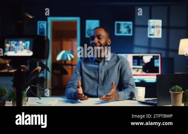 Happy influencer in cozy house using professional camera to film live ...