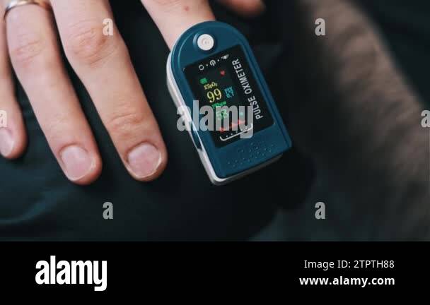 Pulse oximeter measures pulse and oxygen saturation on a male finger ...