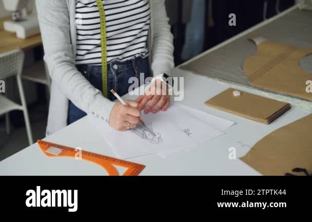 Tilt-up shot of creative clothing designer concentrated on drawing ...