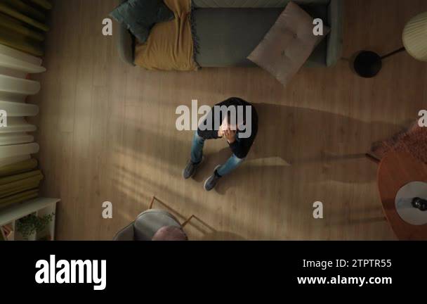 Top view of a man sitting on the living room floor. A depressed man ...