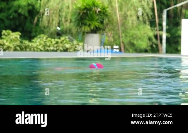 Little girl plays in the outdoor swimming pool of tropical resort ...