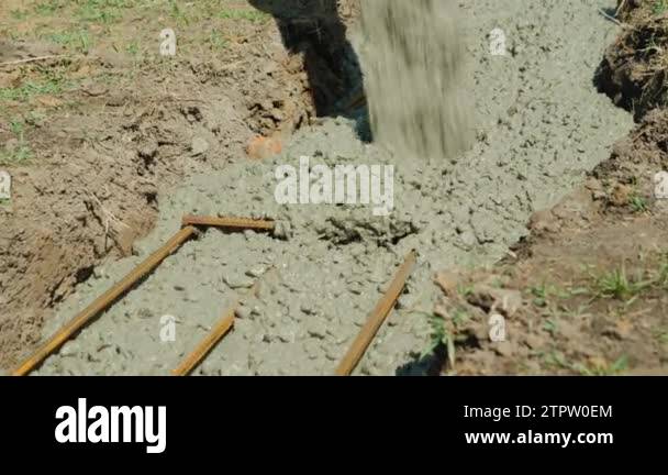 Concrete flows through the pipe into the foundation of the basement ...