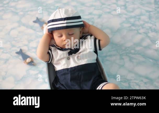 Cute toddler baby boy sleeping in wooden boat with fishes, starfish and ...