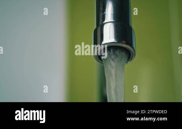 Close-up of water flowing from a kitchen faucet. drinking water from ...