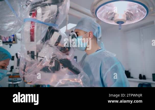 Neurosurgery through the microscope. Medical specialist looking into ...