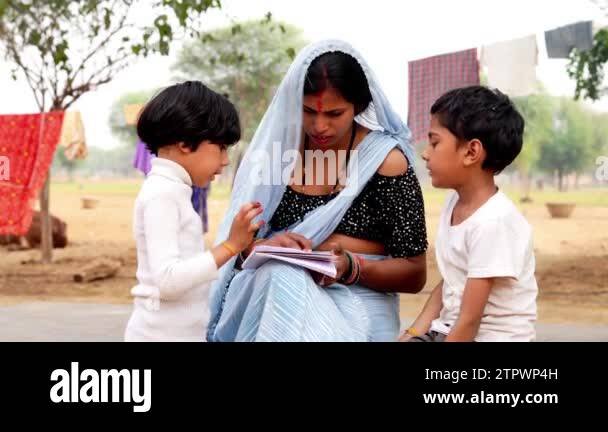 Beautiful Indian woman in traditional costume helping her daughter and ...