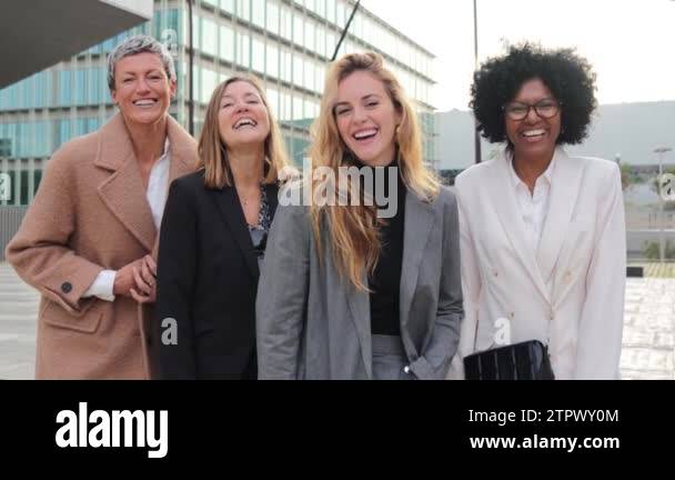 Group of proud businesswomen smiling and looking at camera at workplace ...