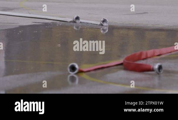 An up-close shot captures a fire hose with a powerful stream of water ...