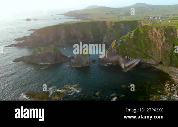 Dunquin or Dun Chaoin pier, Irelands Sheep Highway. Aerial view of narrow pathway winding down ...
