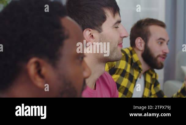 Excited young multi-ethnic emotional men screaming cheering for ...