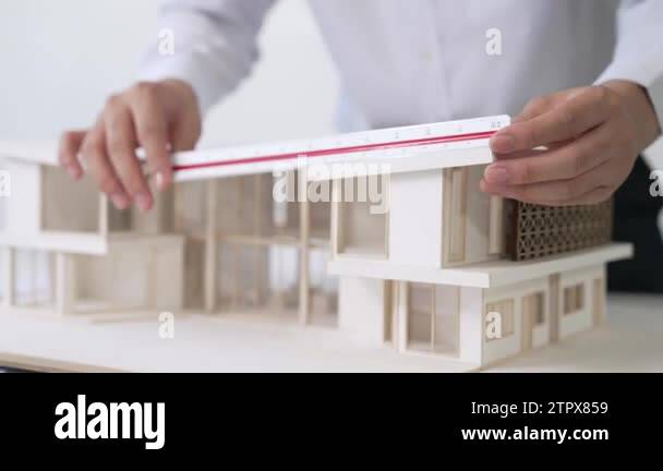 Professional male architect using ruler to measure house model length ...