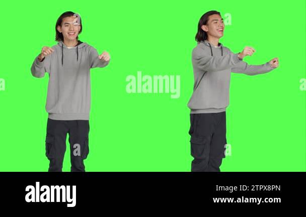 Asian guy acting as choir conductor for musical show, moving hands like ...