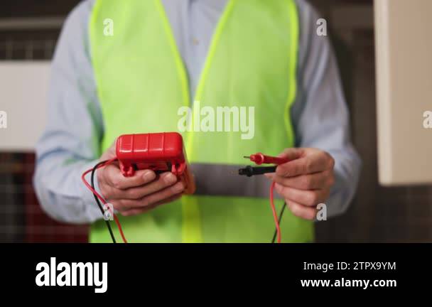 Close up hands of skilled electrician with electrical tester inspecting ...