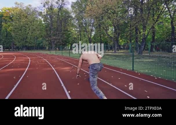 Male sprinter training for race. Back view of athlete without shirt ...