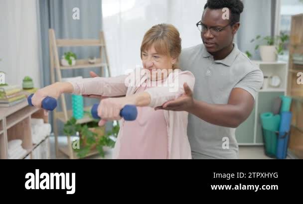 Physiotherapy, arms and senior woman with black man and dumbbell for ...