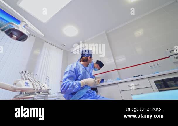 Modern dental office. Dentist is preparing tools for treating teeth in clinic. Doctor is using ...