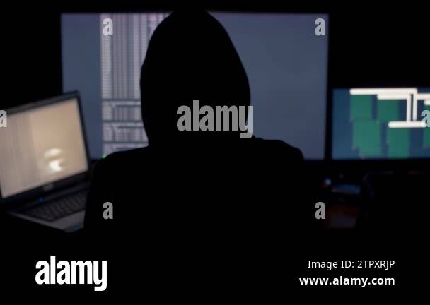 Hacker In Hood Cracking Code Using Computers In Dark Room Stock Video