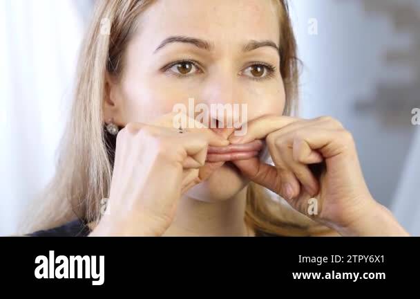 prevention of skin aging, woman performs exercises for a face building ...