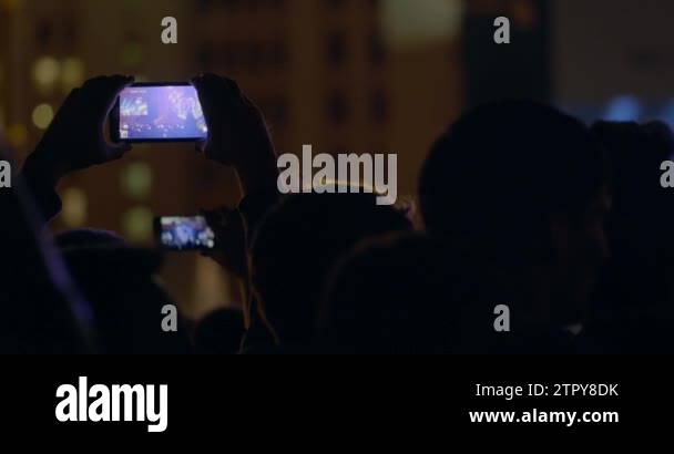 Spectator man recording video with zoom of stage and big screen via ...