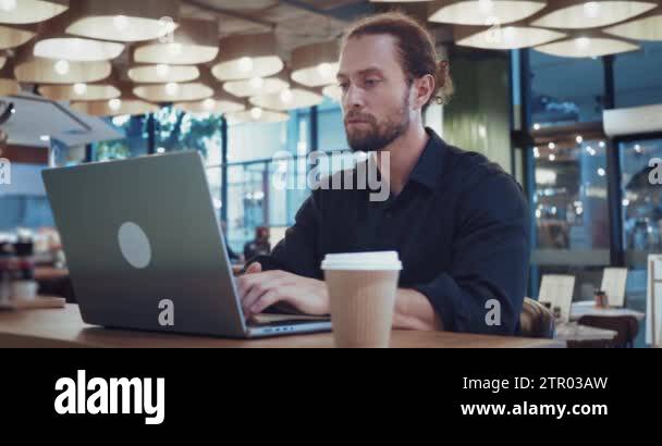 Concentrated man sitting in coffee shop improving digital skills at ...