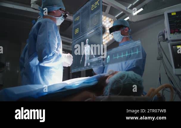 Surgeons operate patient in modern hospital operating room wearing AR ...