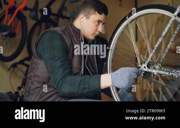 Skilled mechanic is rotating bicycle wheel checking mechanism and ...