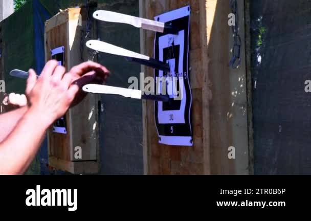 Men's hands get a knife from the target. Throwing knives at the target ...