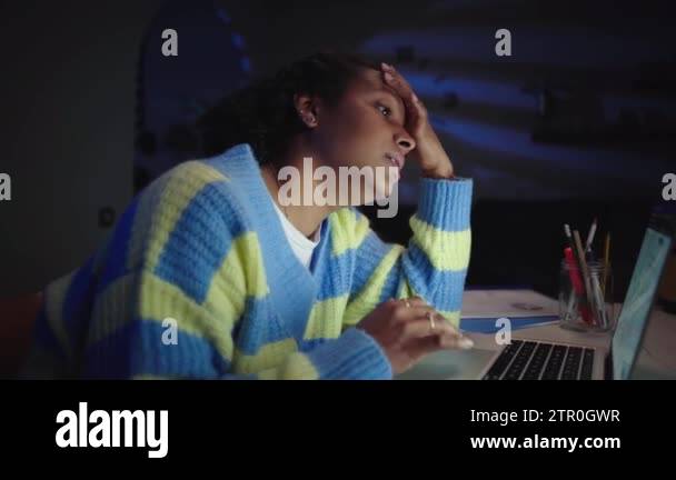 Young black American female college bored and tired, writing and using ...