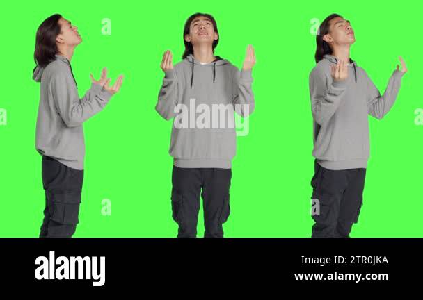 Model with belief praying to God against greenscreen studio backdrop ...