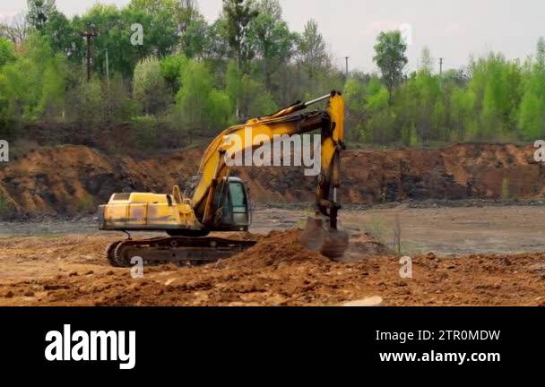 Earth moving equipment. Yellow excavator digging the ground. Excavator ...