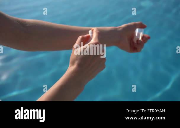 Female hands applying serum or moisturizing oil from a jar on the skin ...