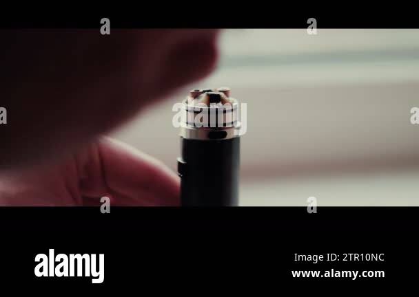 Man filling an electronic cigarette with e-juice. Man detaching the ...