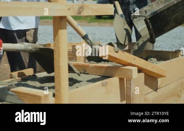 Making a socle in a private house. Workers pour concrete into the ... Making a socle in a private house. Workers pour concrete into the ...