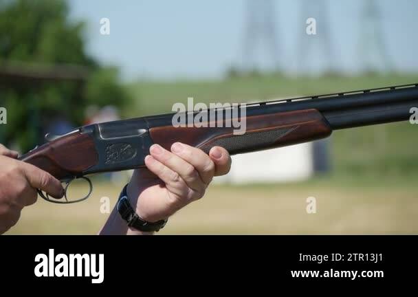 Man is practicing on a skeet range with his rifle in summer in slow ...