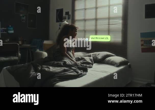 African American Teen Girl Sitting On Bed In Dark Room Receiving Threatening Message And